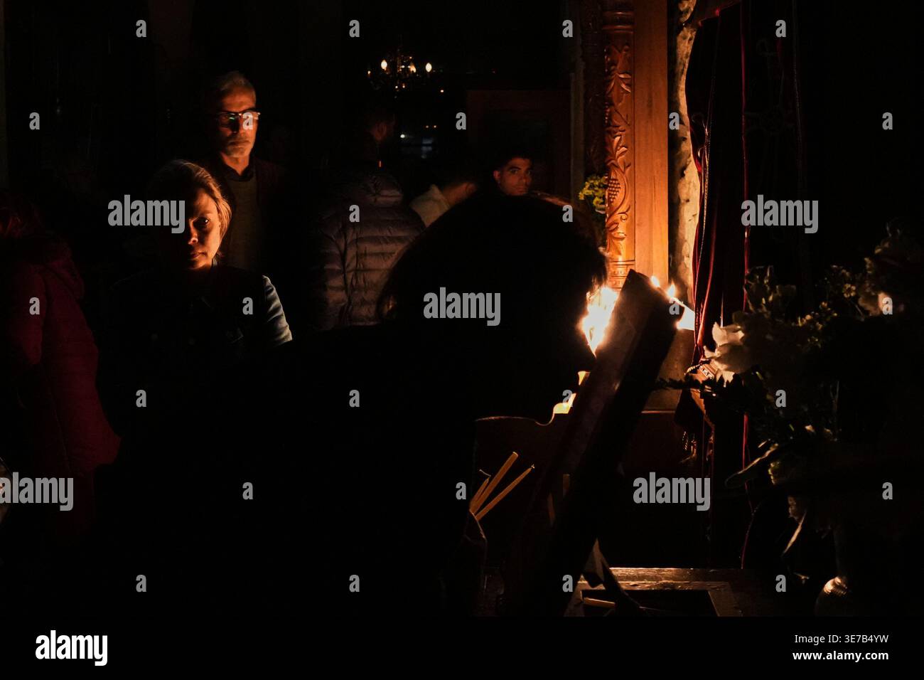 Orthodox Christian worshipers light candles and kiss an icon while ...