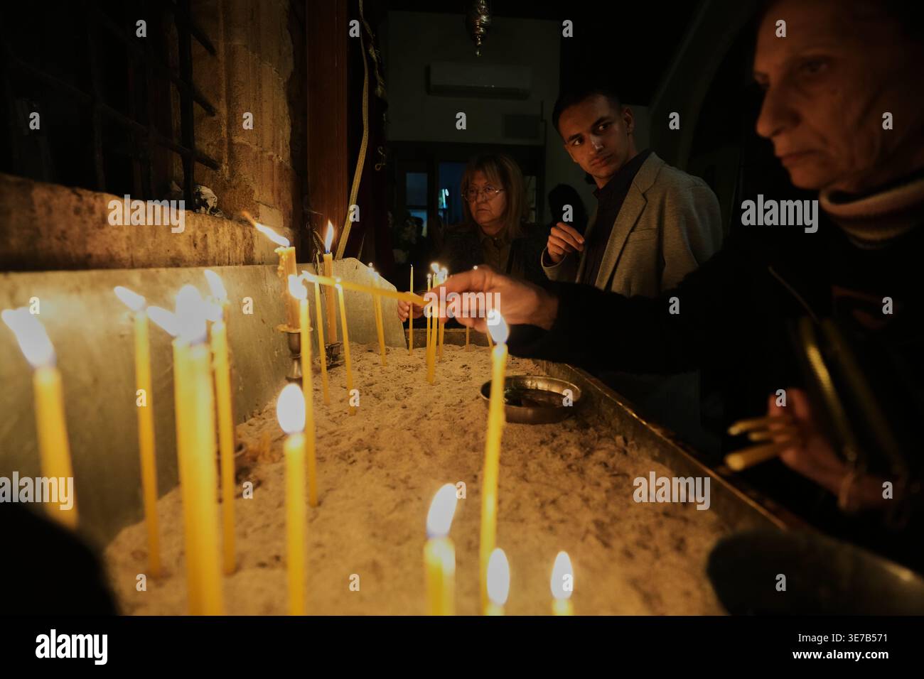 Orthodox Christian worshipers light candles while holding aloft the ...
