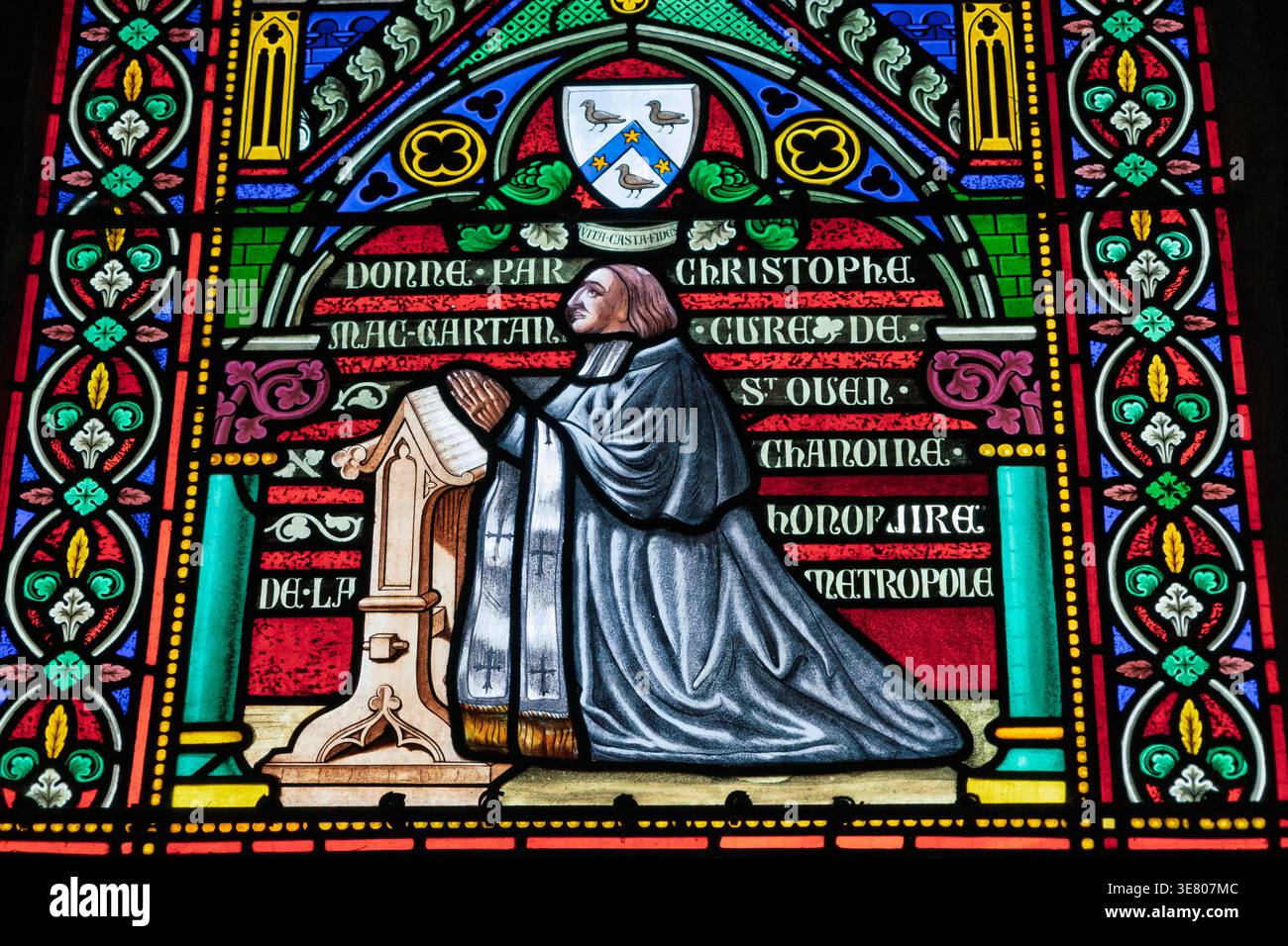 Neo-Gothic stained glass window depicting priest Christophe Mac-Gartan ...