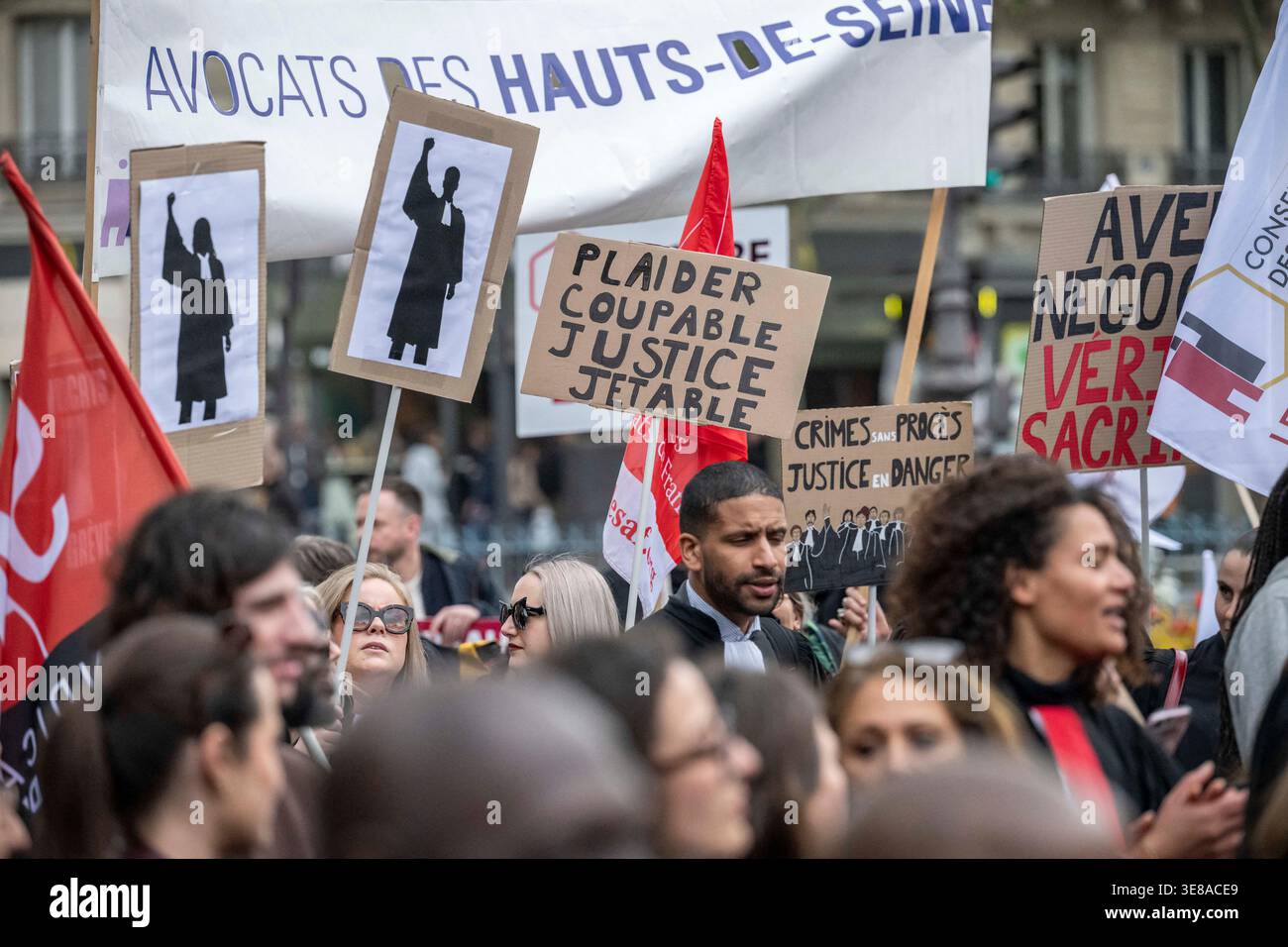 A lawyer holds a placard during a demonstration against the Darmanin ...
