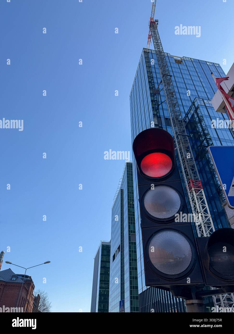 Red color light lighting up on traffic light in a big city close up ...