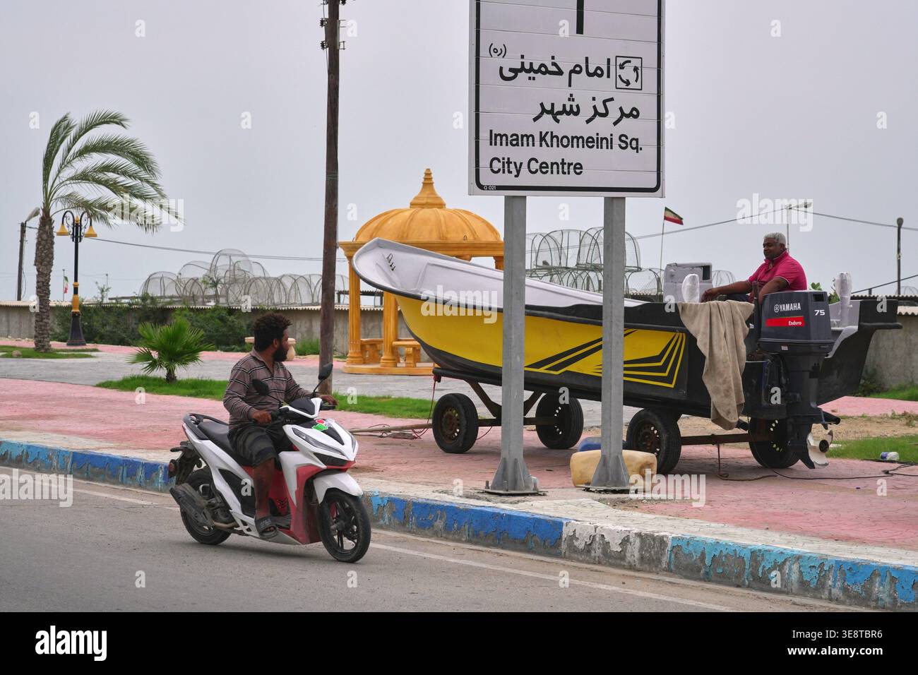 A fisherman carries his boat along the seaside corniche on Qeshm Island ...