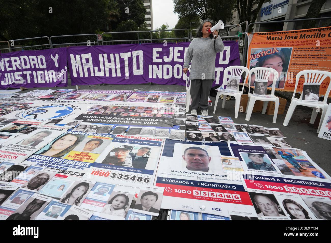 A woman using a bullhorn joins relatives and friends of missing persons ...