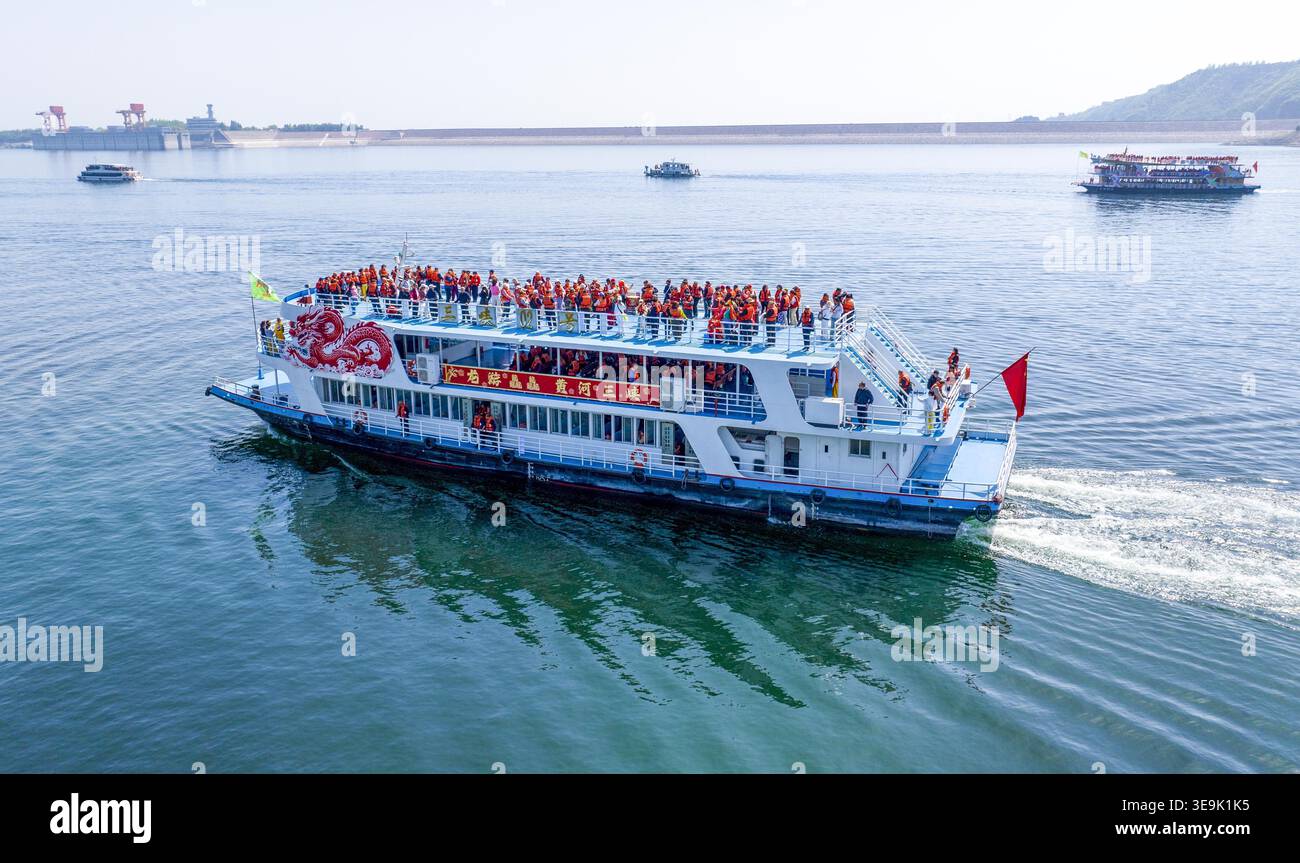 Tourists board a boat to the Yellow River Three Gorges scenic area at ...