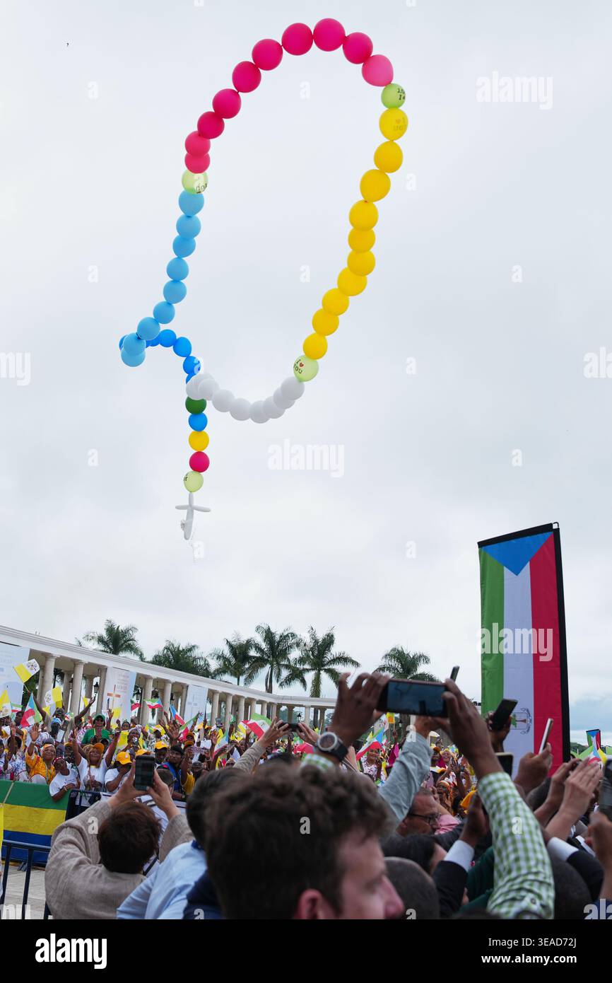 A rosary-shaped cluster of balloons floats above faithful at the ...