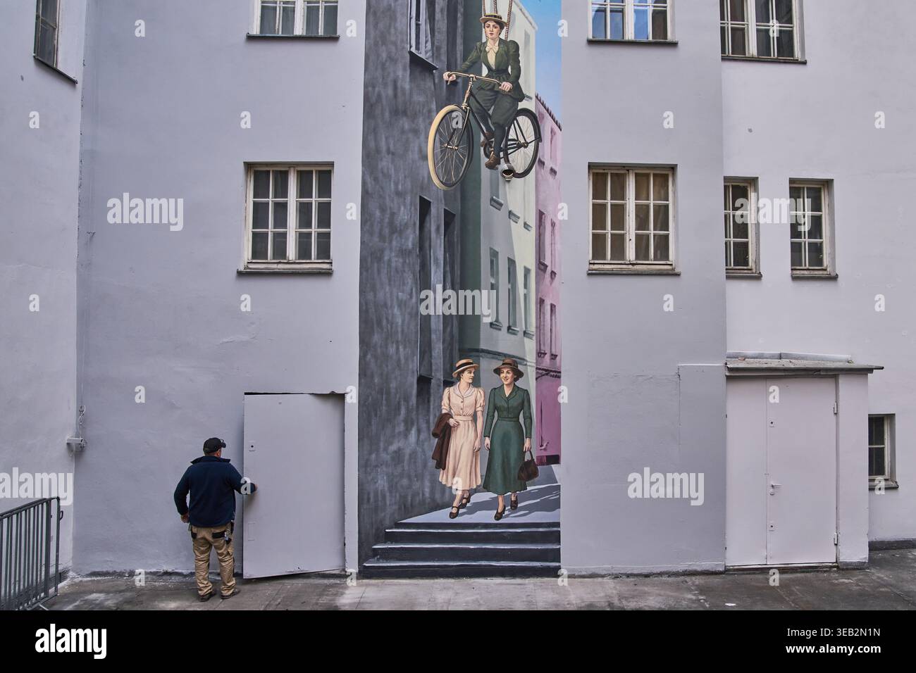 A man walks through a courtyard featuring a mural in central Warsaw ...