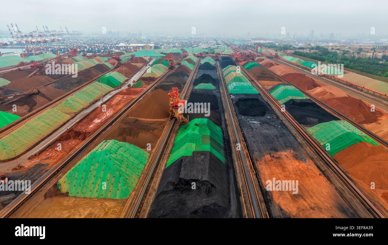 Workers handle cargo at the iron ore terminal of Qingdao Port in east ...