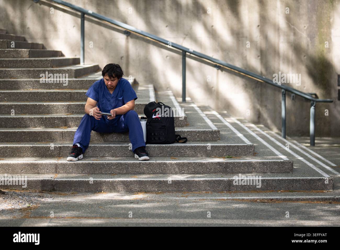 A hospital worker sits outside of the Vancouver General Hospital in ...
