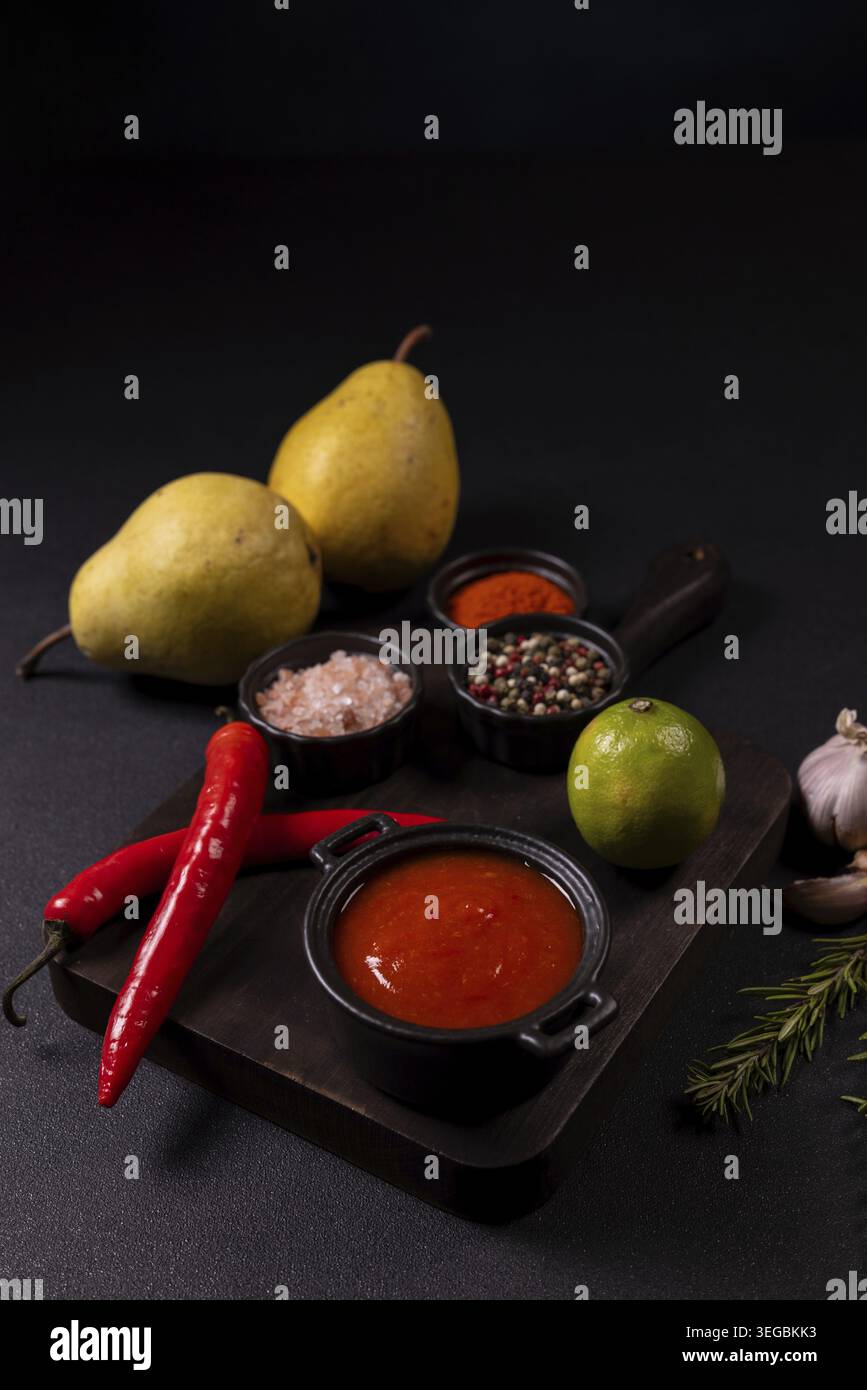 Red chili sauce in a black bowl surrounded by fresh red chillies ...