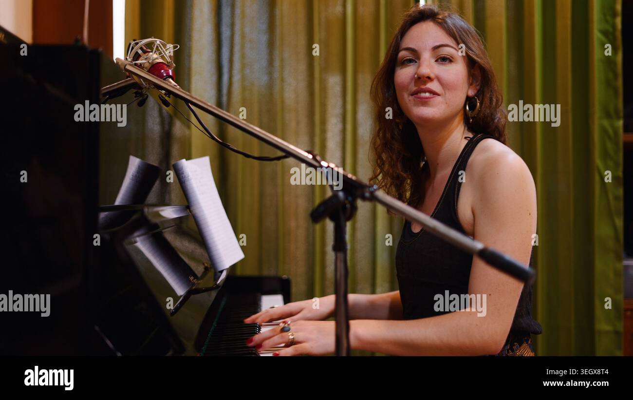 Woman playing piano and singing in recording studio session Stock Photo ...