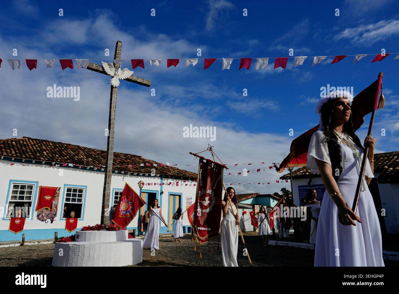 Flag-bearing relevers partake in a procession at the Holy Spirit ...