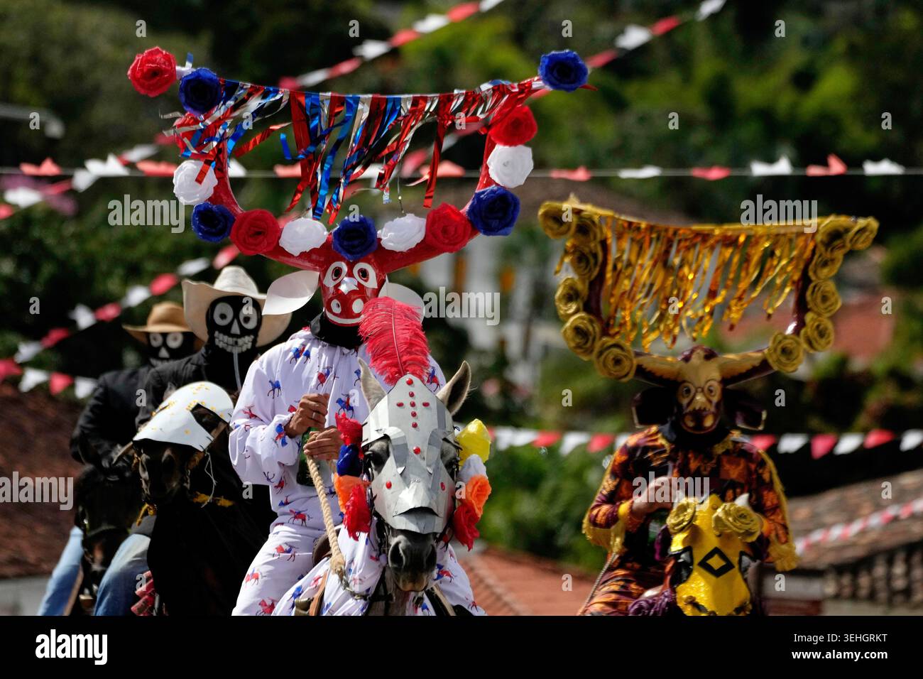 Revelers wearing traditional bull-head masks take part in the ...
