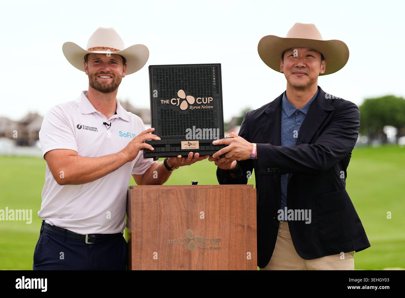 Wyndham Clark, left, is presented the trophy by Pious Jung, right, co ...