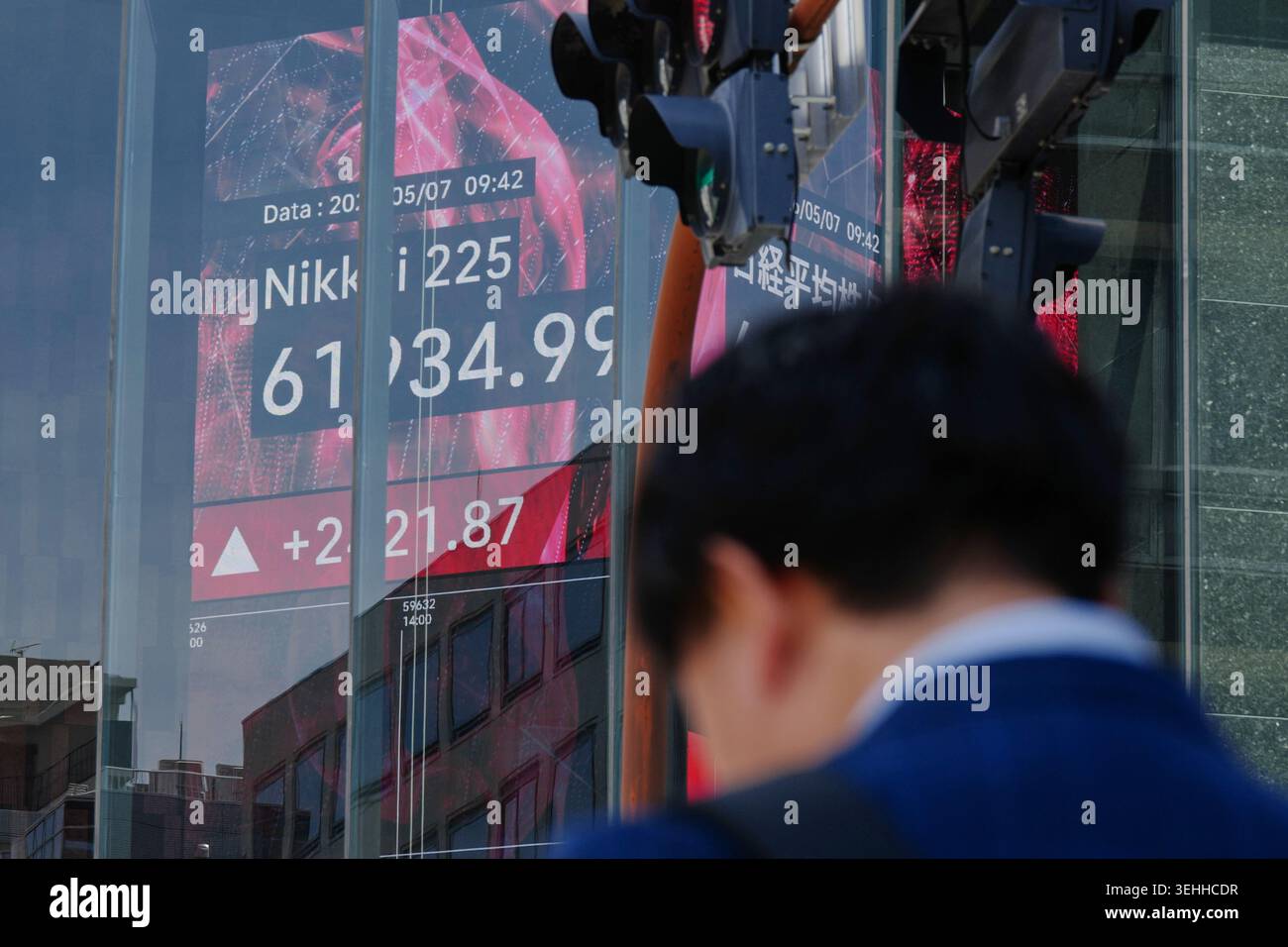 FILE - A person stands in front of an electronic stock board showing ...