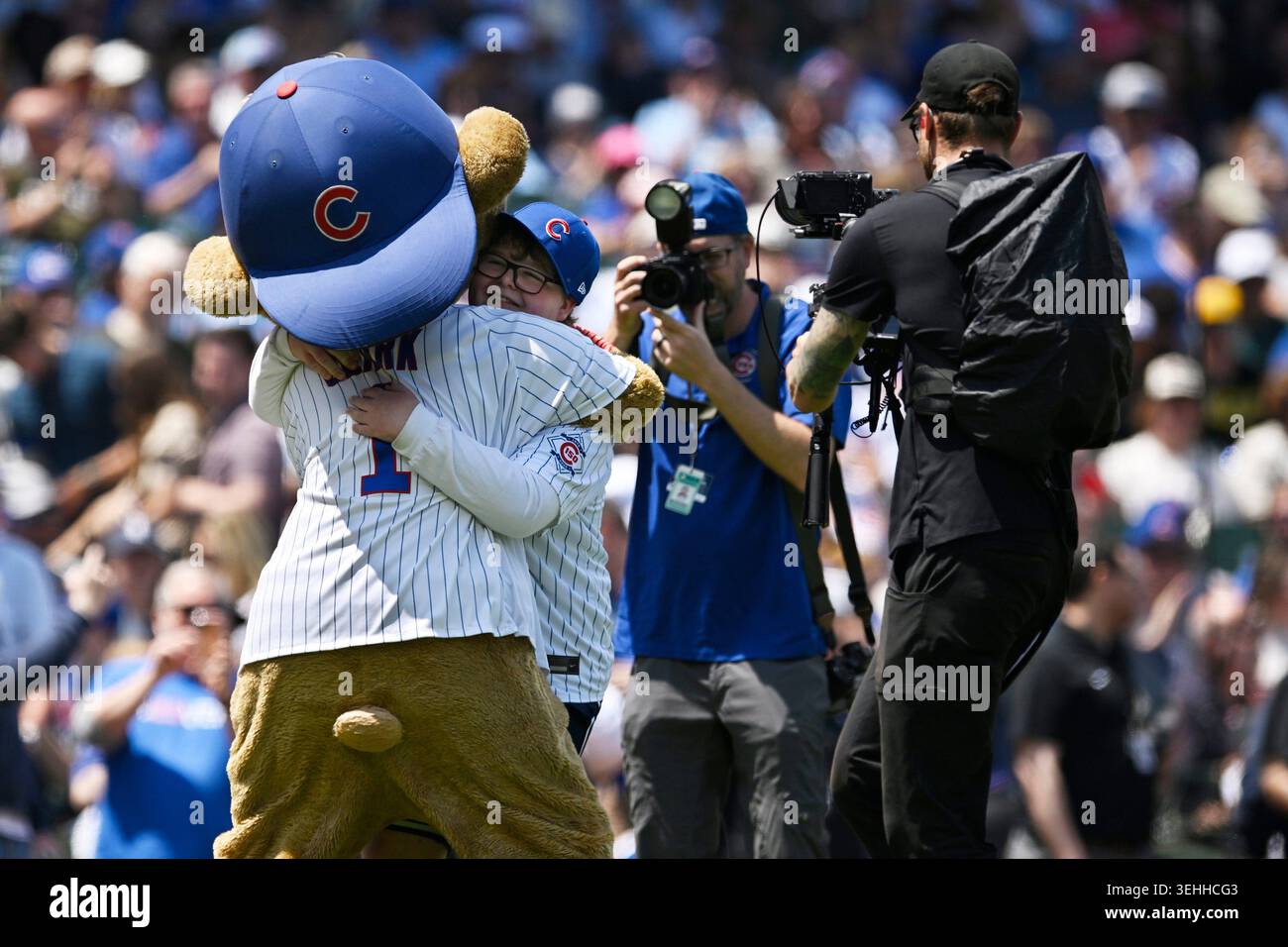 Actor Jake Connelly hugs Clark the Cubs mascot after throwing out the ...