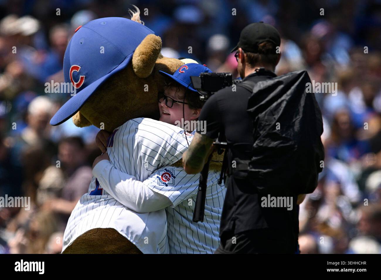 Actor Jake Connelly hugs Clark the Cubs mascot after throwing out the ...