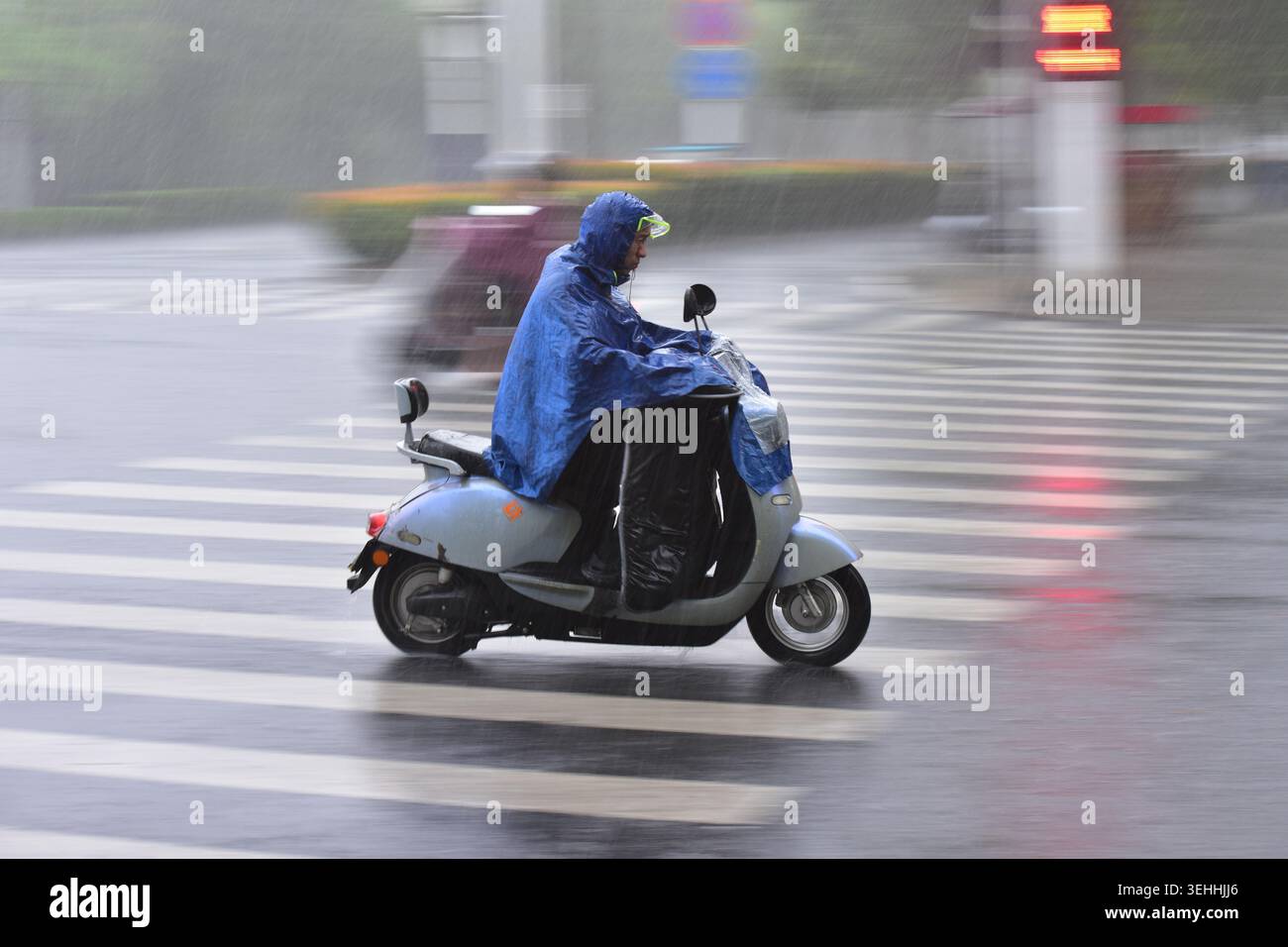 Citizens ride bicycles in the rain on a street in Fuyang, east China's ...