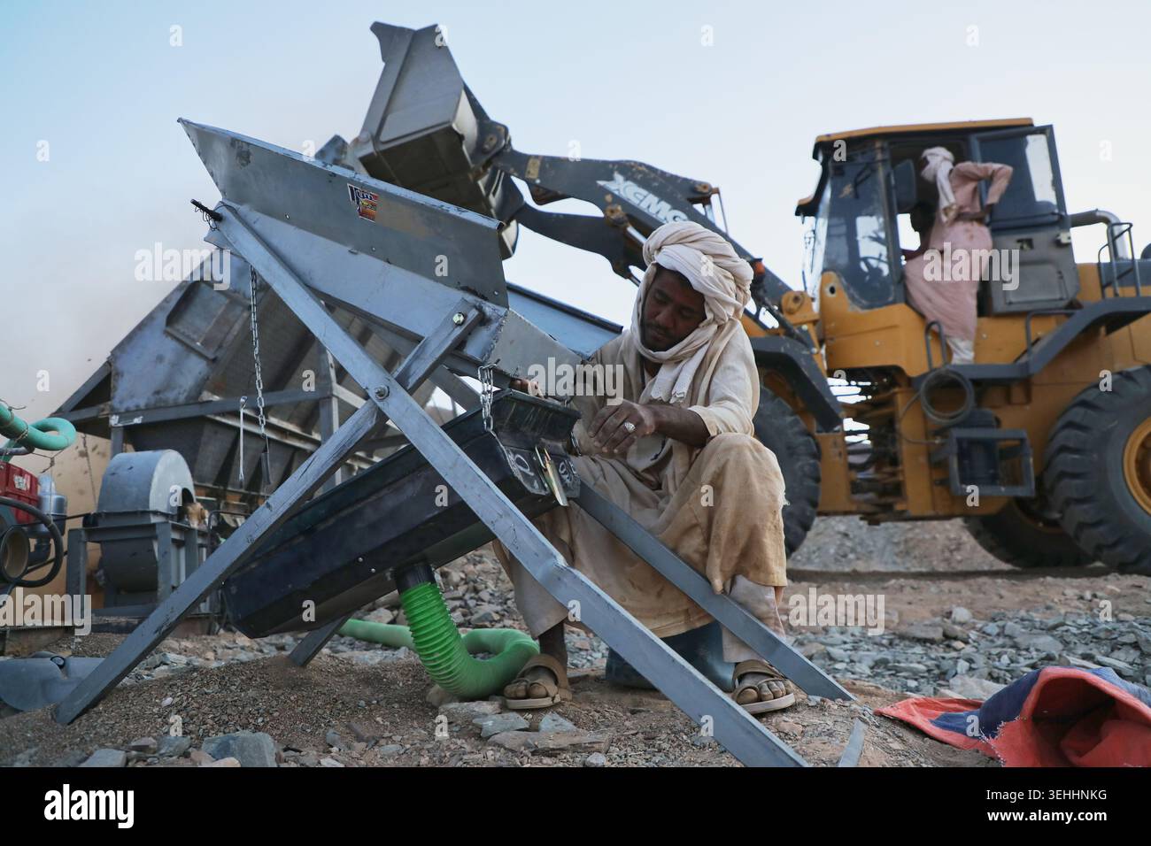 An artisanal miner operates an ore-processing machine used to separate ...