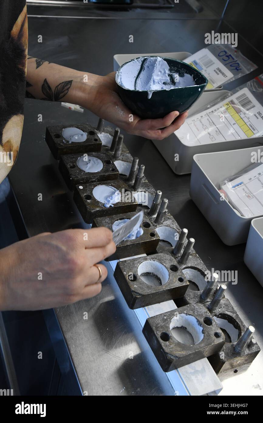 An eye technician using a small tool to place a light blue material ...