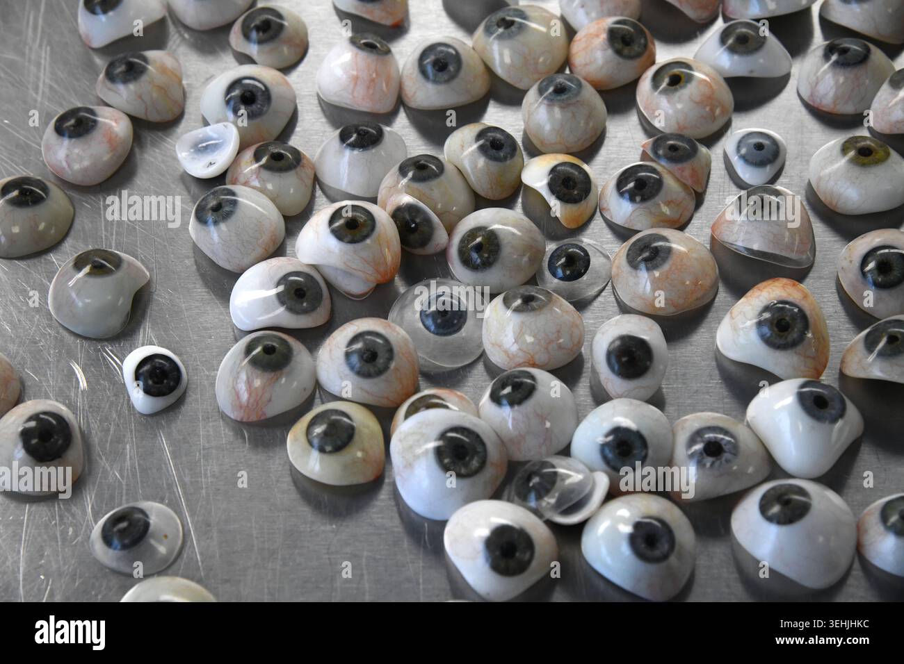 Numerous prosthetic eyes of various colors and sizes are scattered ...