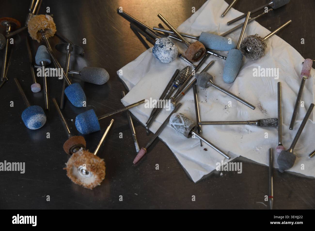 Various rotary grinding and polishing cutters are scattered on a metal ...
