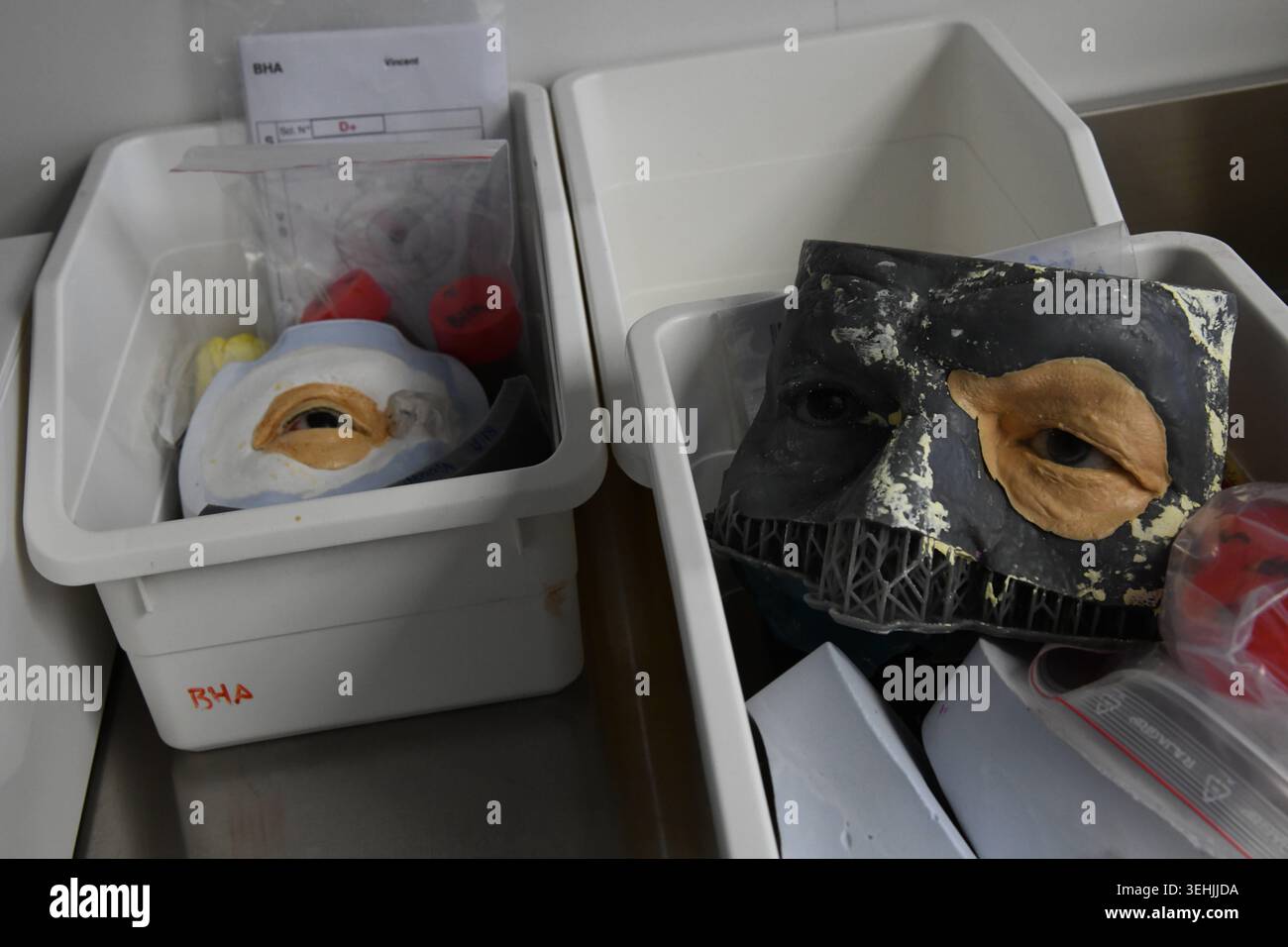 Two white plastic bins contain various objects, including a 3D printed ...