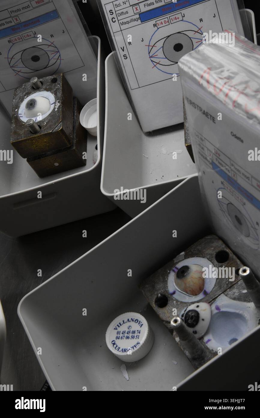 Prosthetic eyes in metal molds and plastic boxes, accompanied by ...