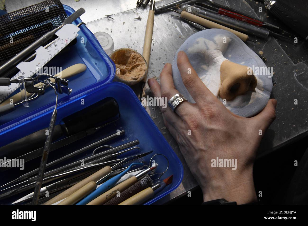 Ocularist holding a light blue mold containing a beige-colored nasal ...