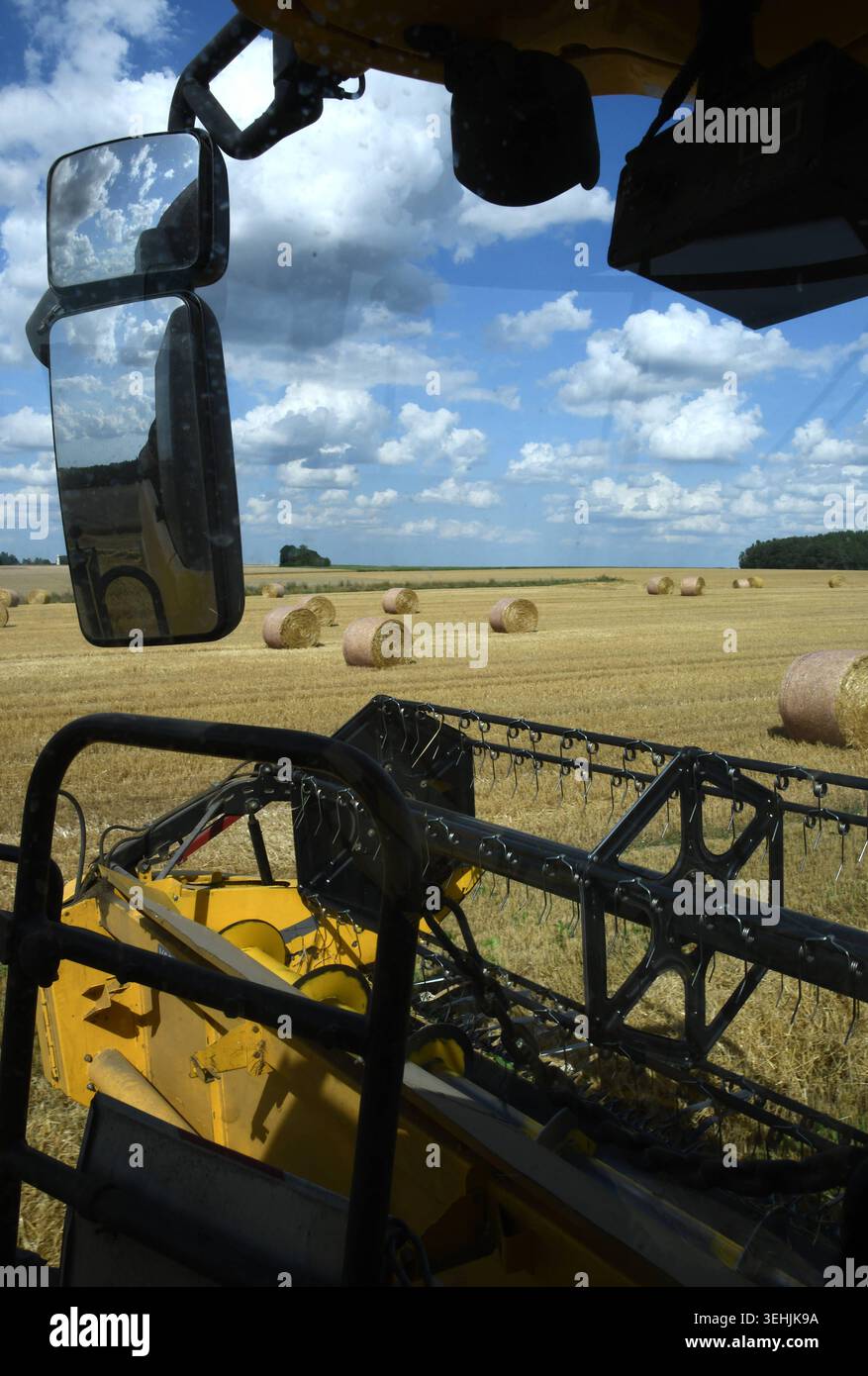 Viewed from inside a yellow harvester, a field of harvested barley ...