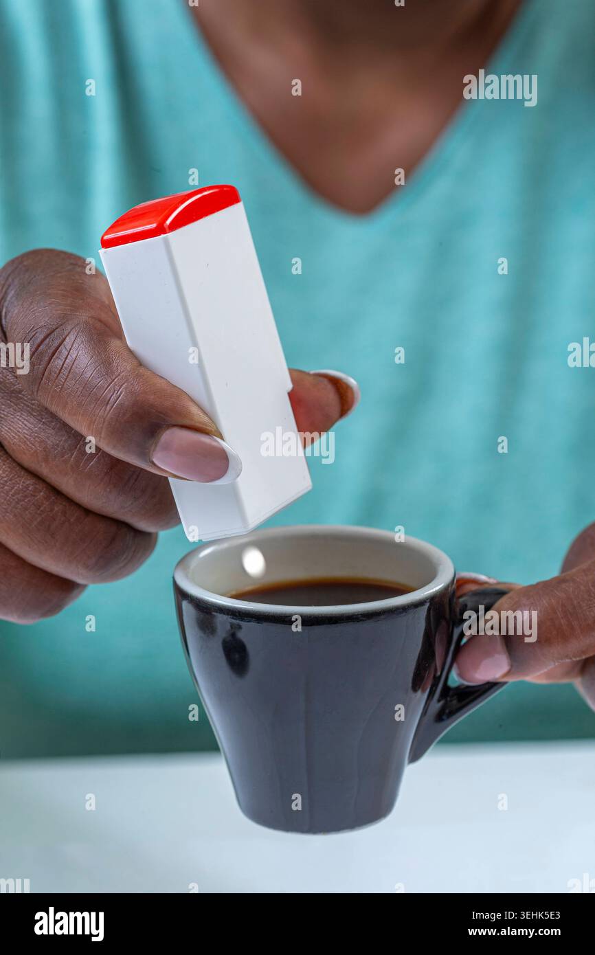 A person holds a Metered-Dose Inhaler above a cup containing a dark ...