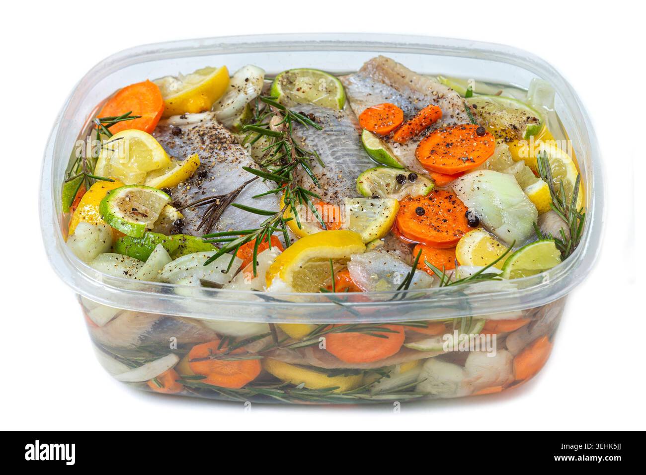 Raw fish fillets, sliced carrots, lemon and lime wedges, onion pieces ...