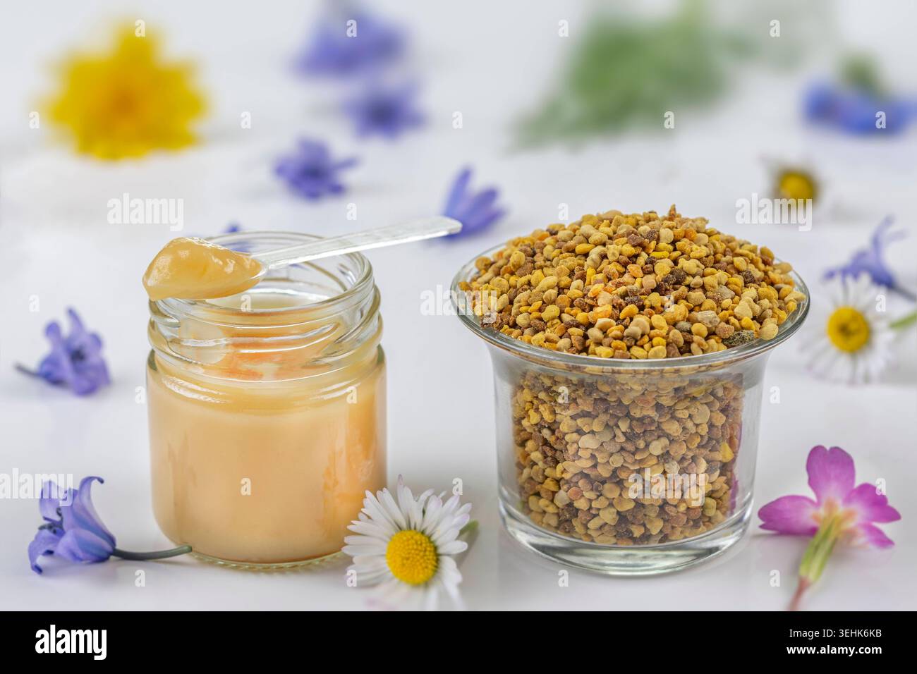 A glass jar containing a viscous yellow substance and a glass bowl ...