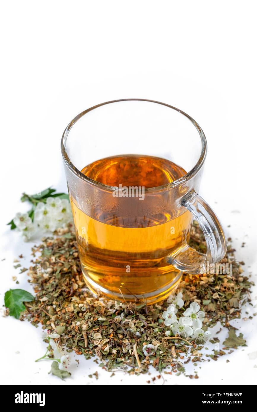 A glass mug containing an amber-colored liquid sits atop a pile of ...