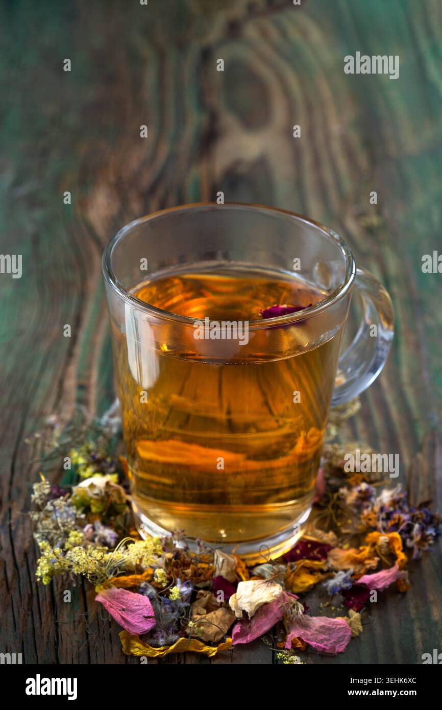 A glass mug filled with amber liquid sits on a wooden surface ...