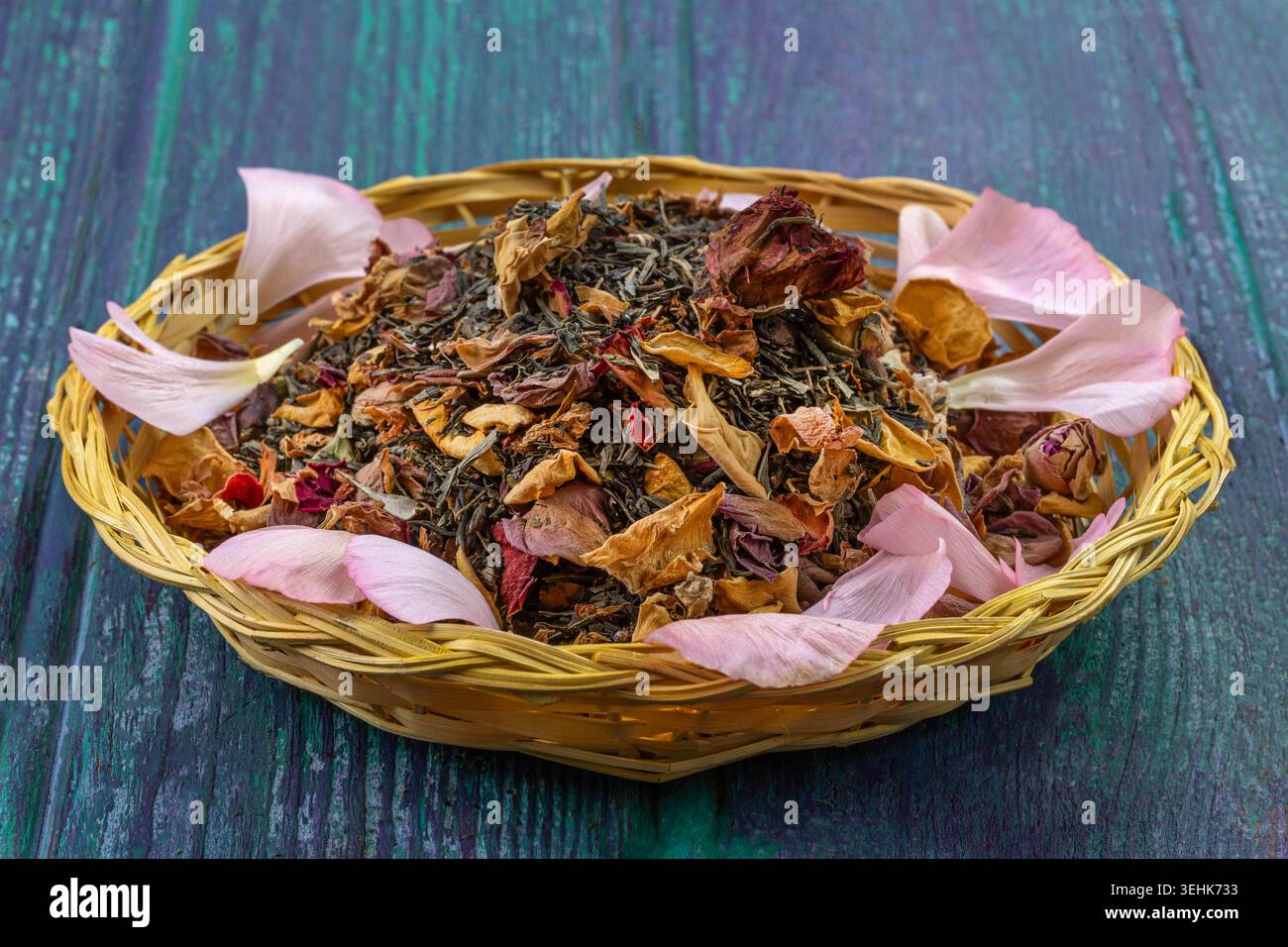 A wicker basket contains dried tea leaves Camellia sinensis mixed with ...