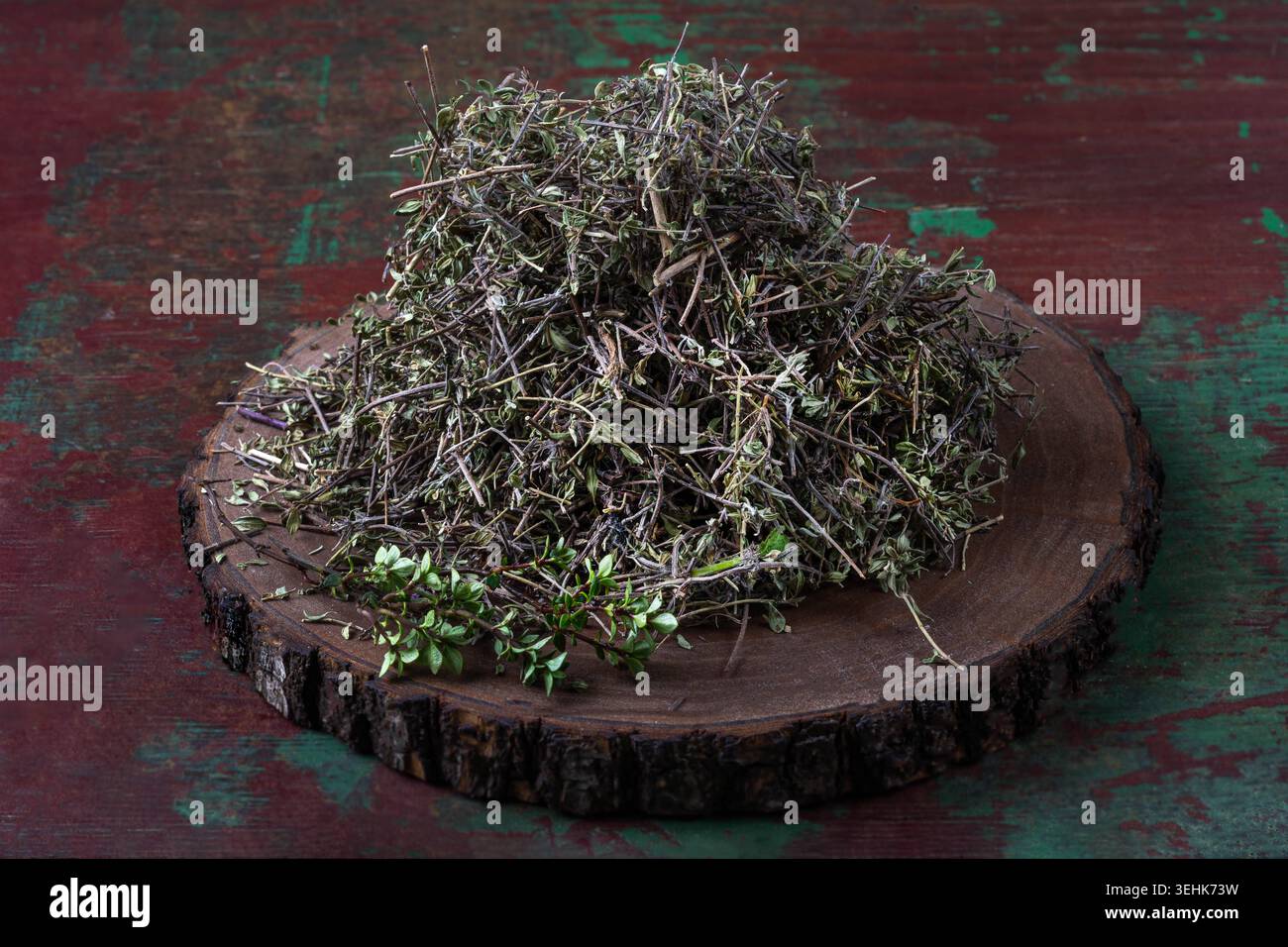 A pile of dried and fresh thyme Thymus vulgaris rests on a circular ...