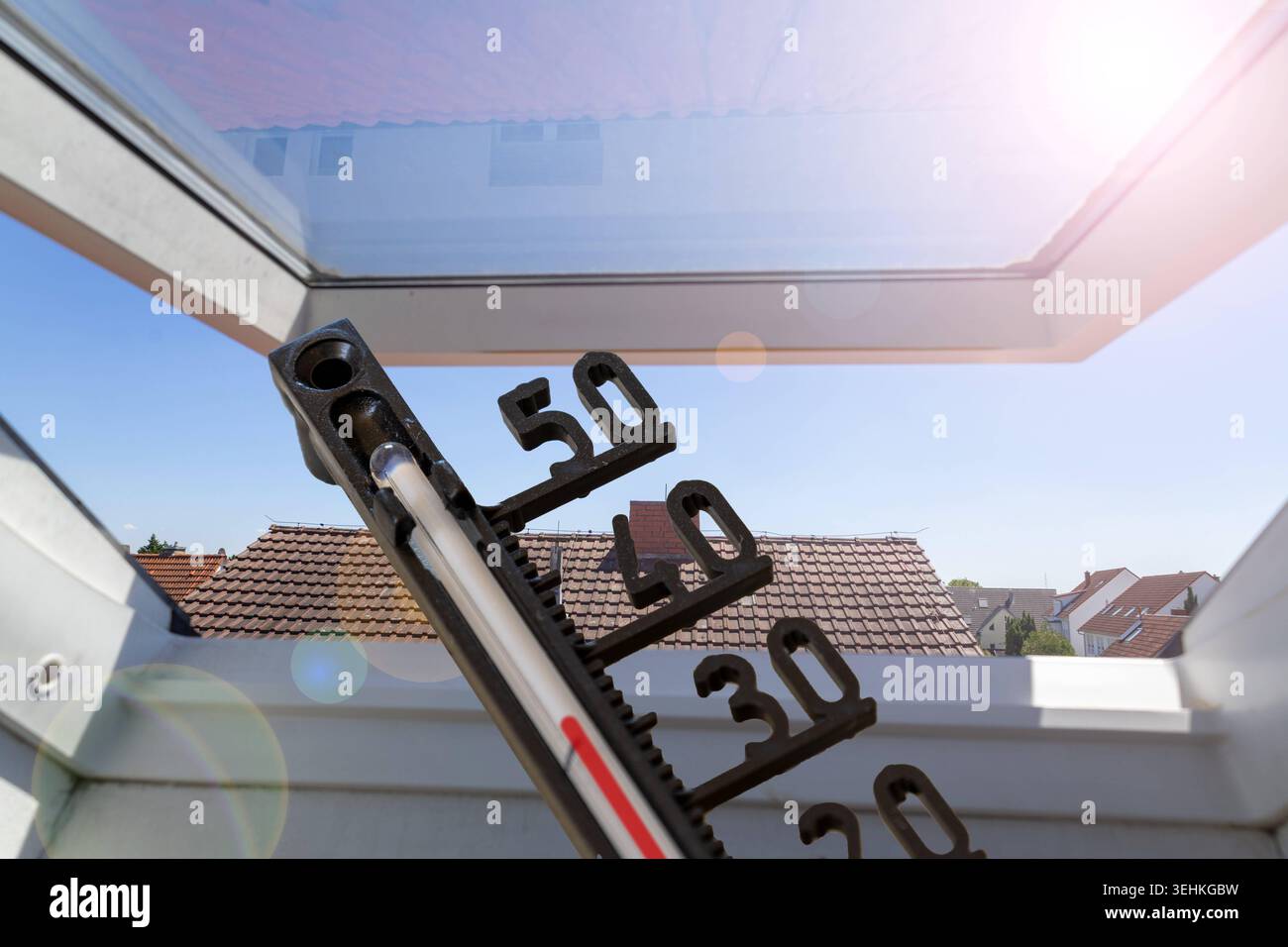 Fotomontage Thermometer vor einem Dachfenster zeigt heiße ...