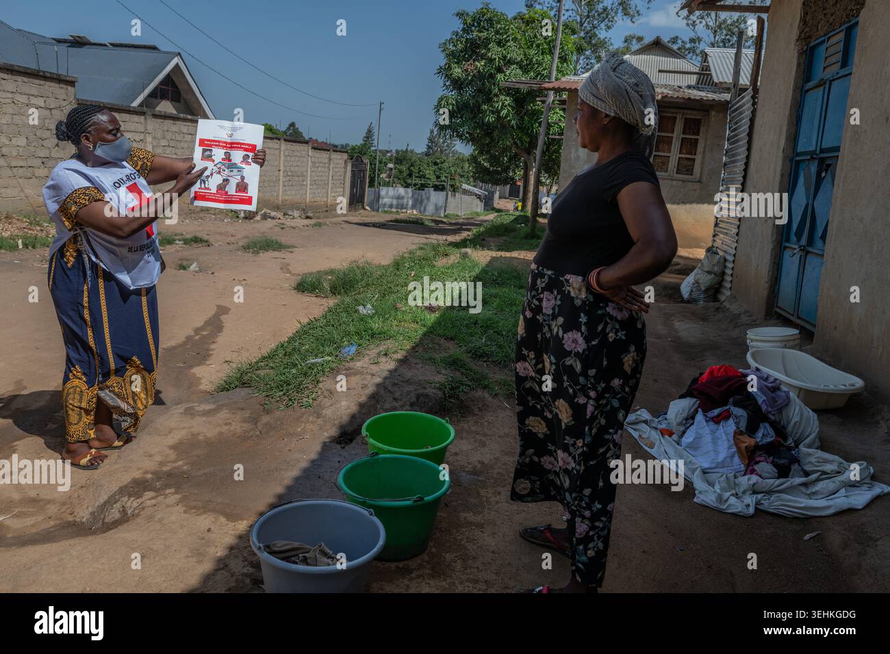 Vanny Birungi, a Red Cross volunteer, speaks to a woman during a house ...