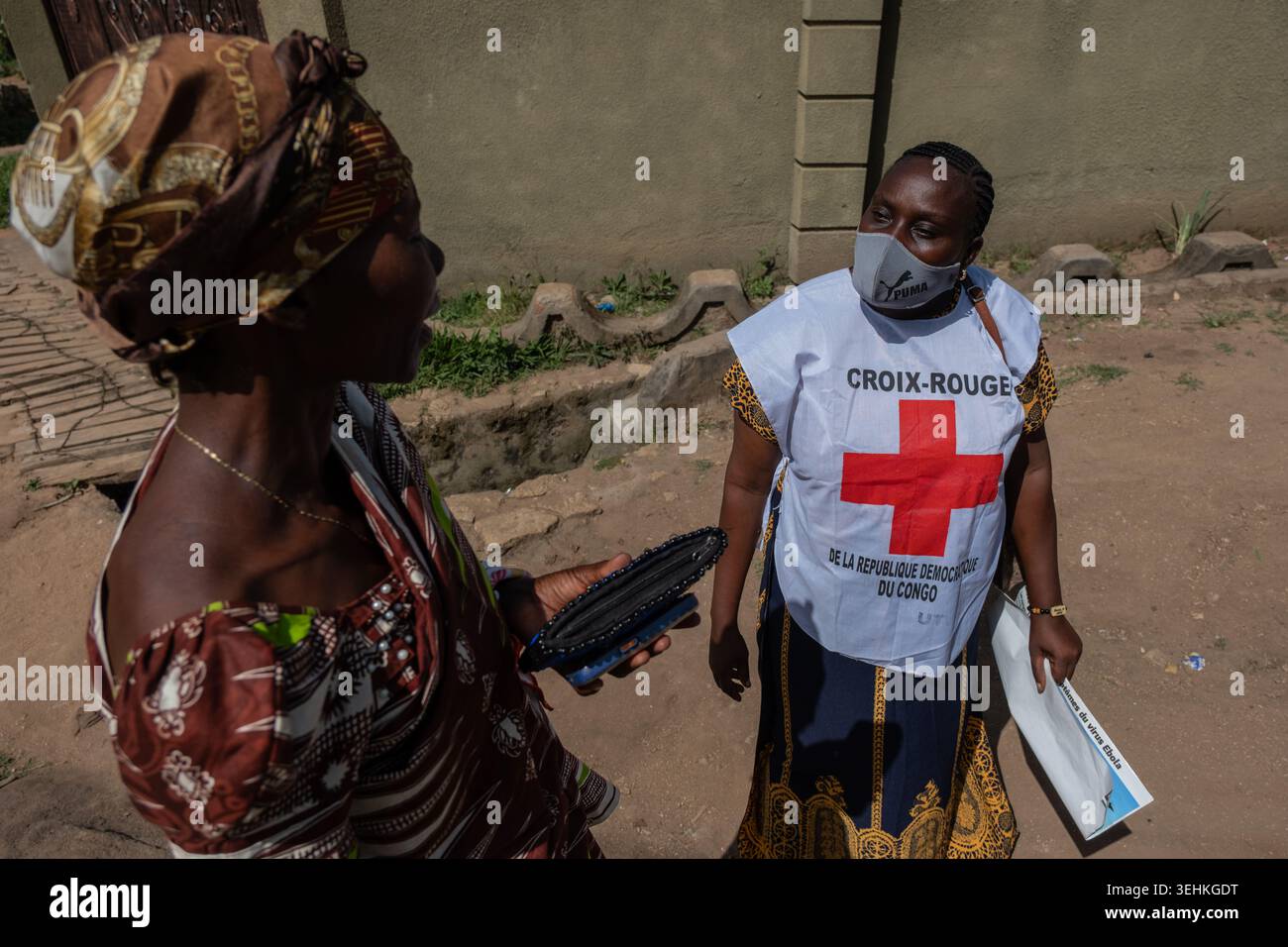 Vanny Birungi, a Red Cross volunteer, speaks to a woman during a house ...