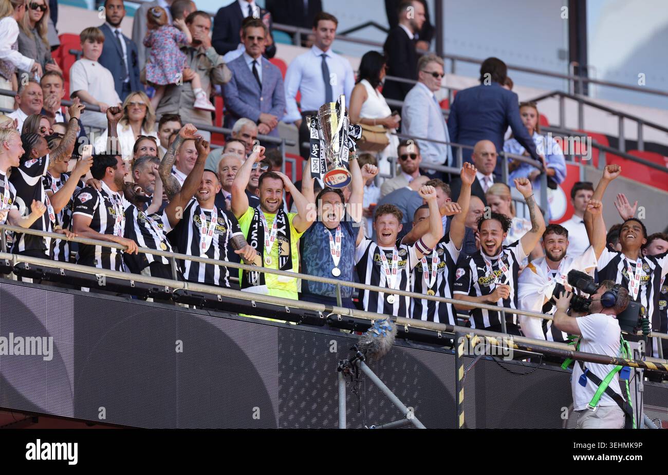 Notts County manager Martin Paterson lifts the trophy with the team ...