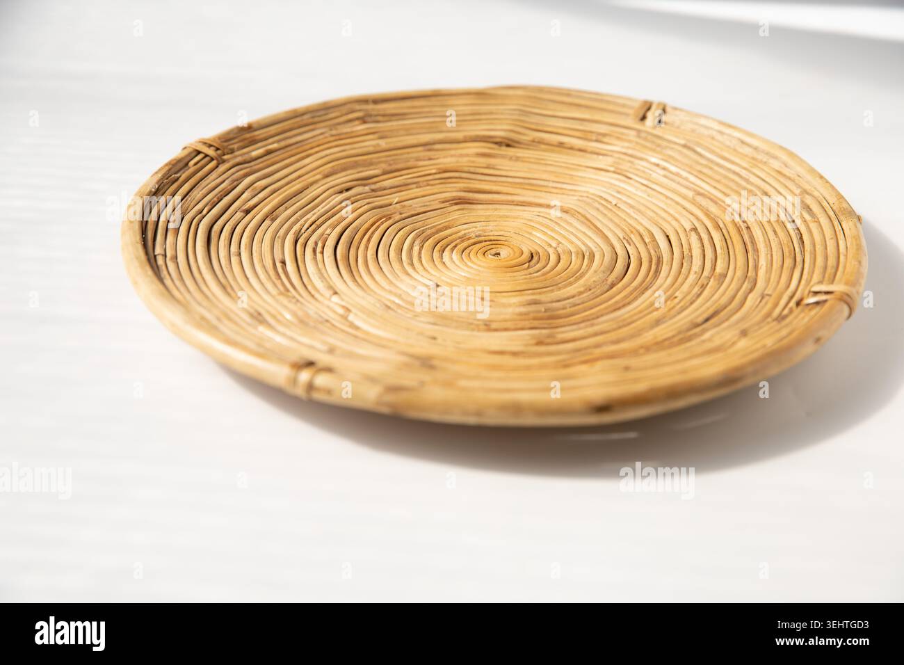 Empty round wicker tray on white background with natural handmade ...