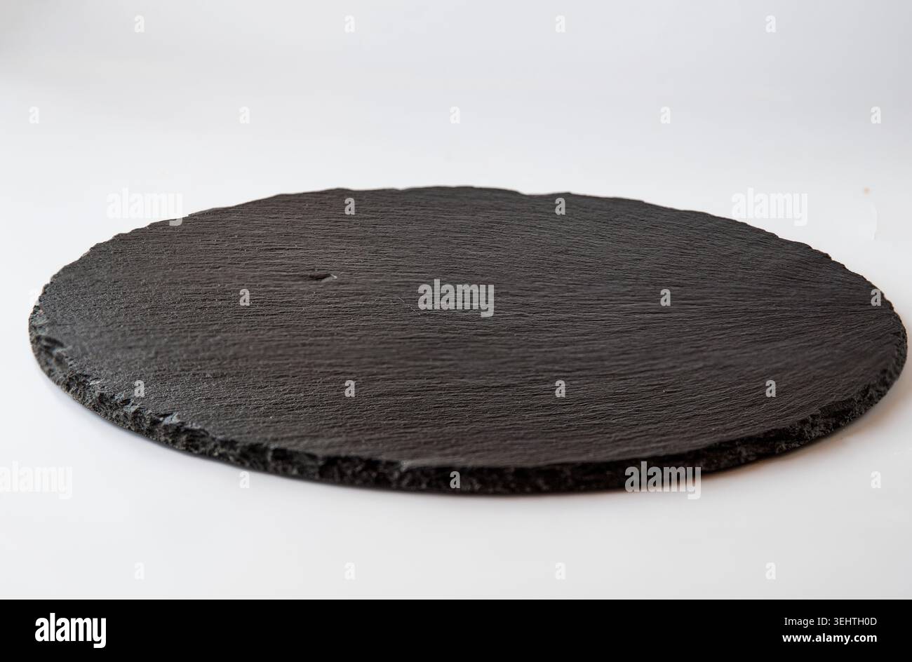 Empty black round slate serving board on white background with rustic ...
