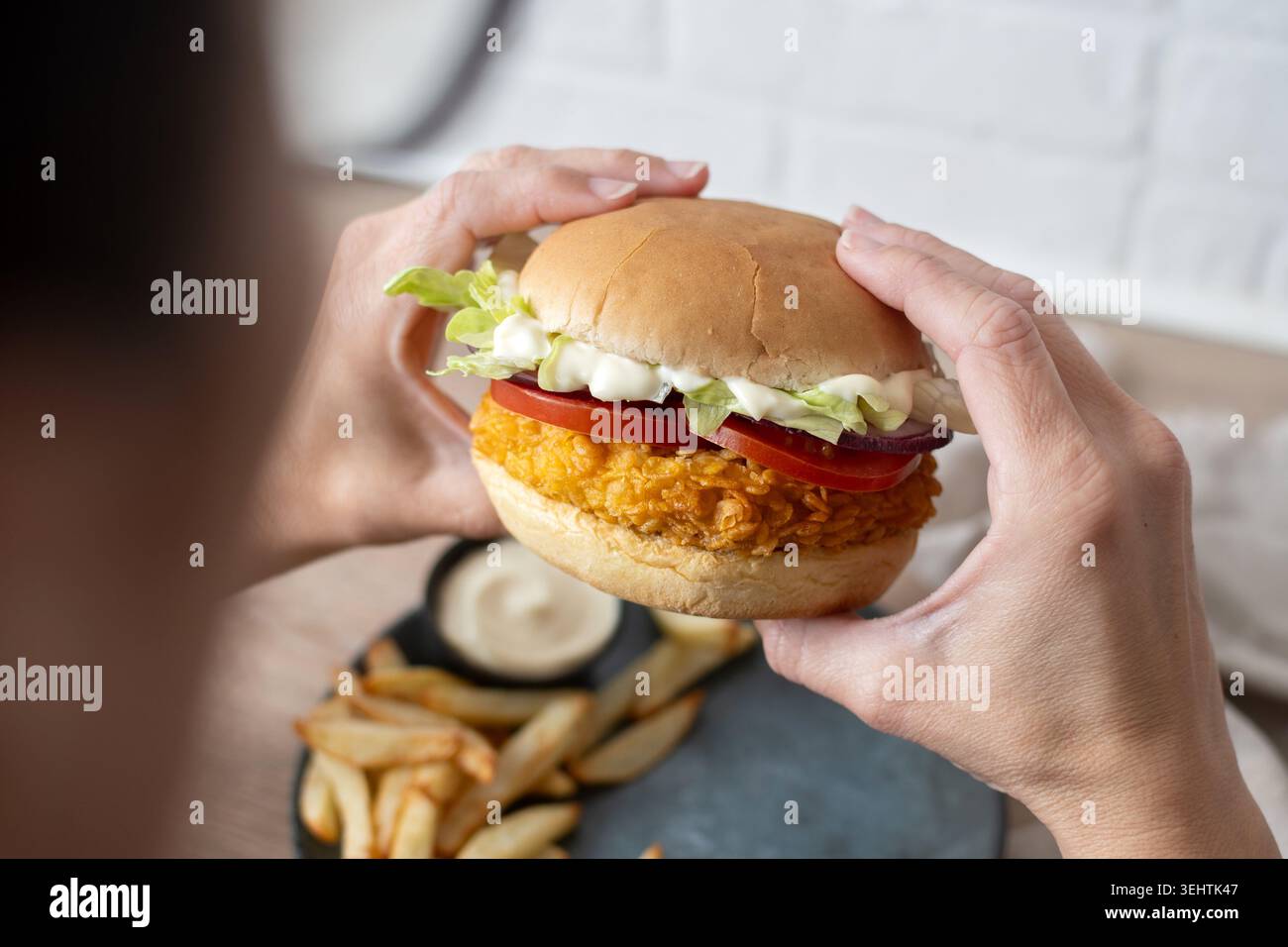 Woman holding crispy chicken burger ready to eat Stock Photo - Alamy
