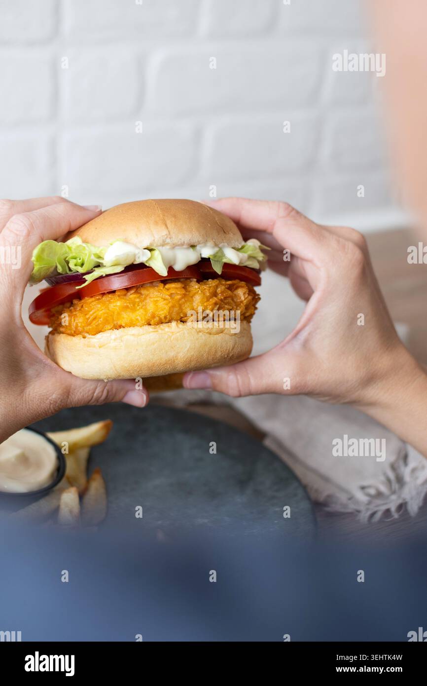 Woman holding crispy chicken burger ready to eat Stock Photo - Alamy