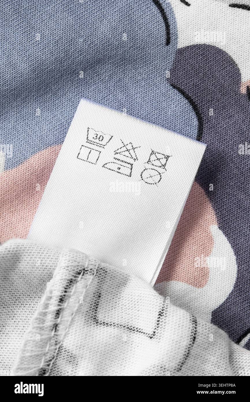 Washing instructions clothes tag label over pastel color cotton fabric ...
