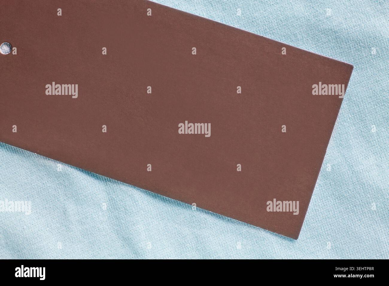 Blank brown paper price tag over light blue fabric background Stock ...