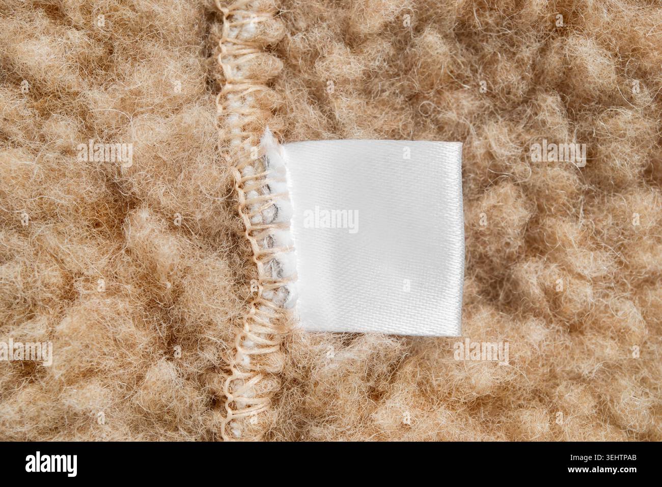 Blank clothes tag on beige wool background closeup Stock Photo - Alamy