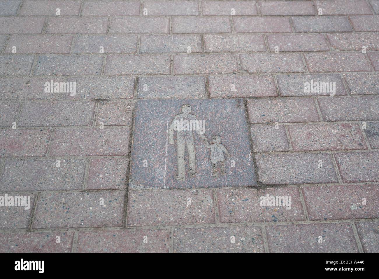Pedestrian pavement symbol with adult and child icon on urban sidewalk ...