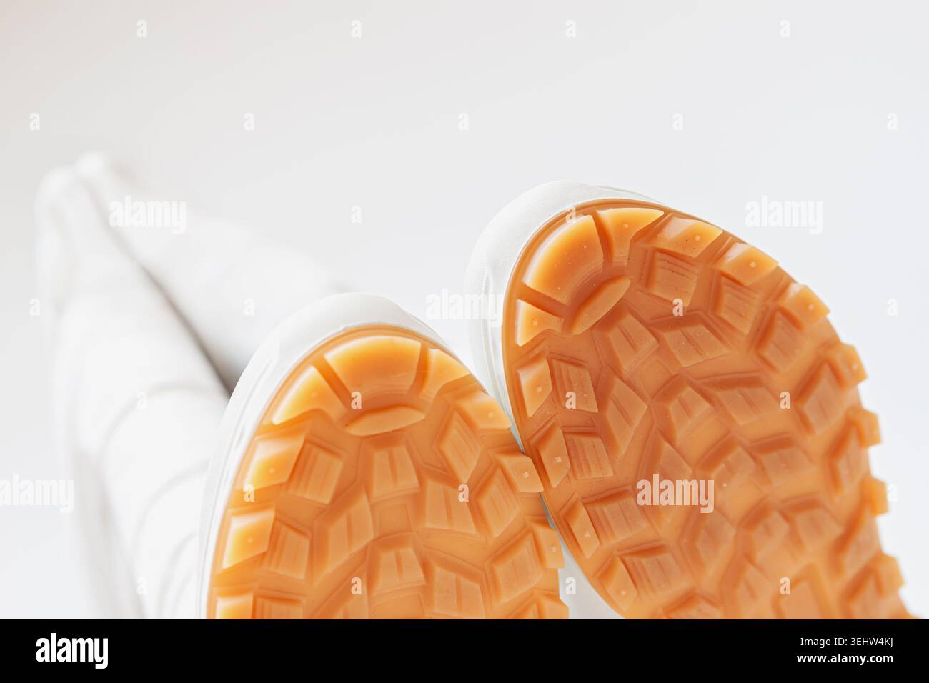 Bottom view of demi season boots with orange rubber sole and tread ...