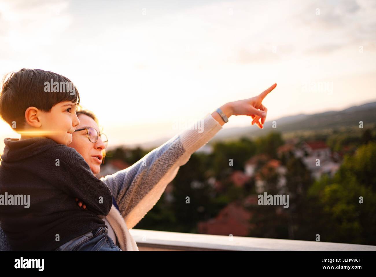 Mother holding child, pointing together, enjoying the scenic view and ...